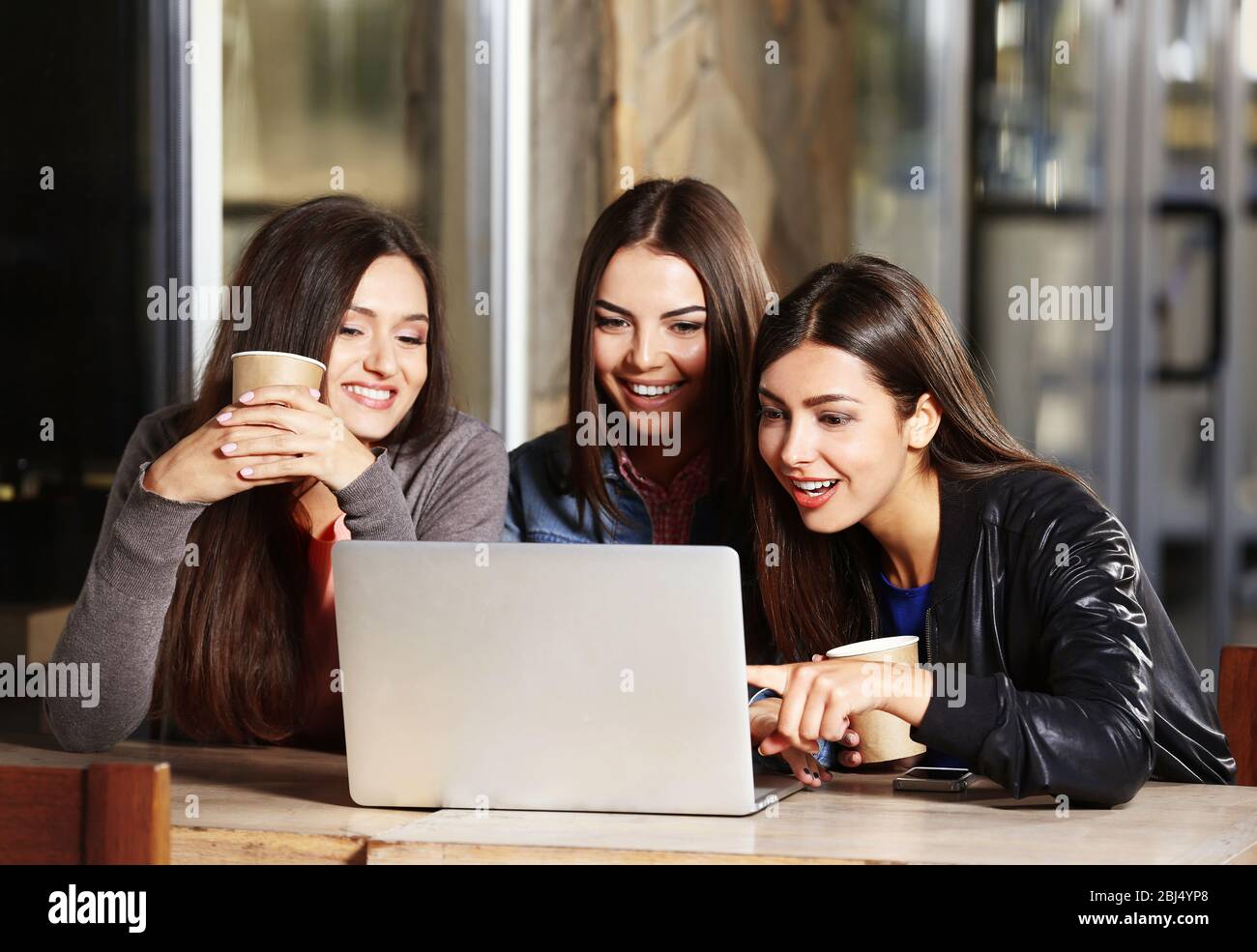 Best friends with laptop together sitting at cafes terrace Stock Photo ...