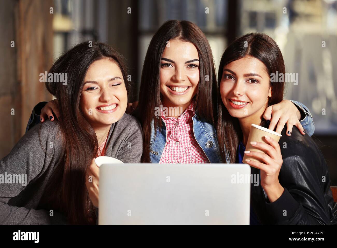 Best friends with laptop together sitting at cafes terrace Stock Photo ...