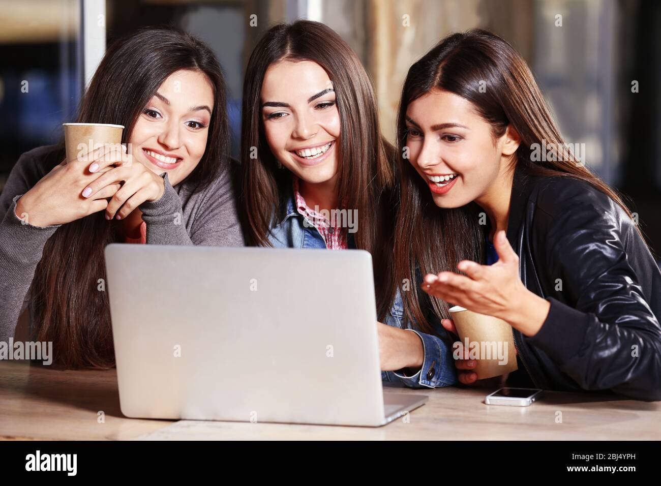 Best friends with laptop together sitting at cafes terrace Stock Photo ...