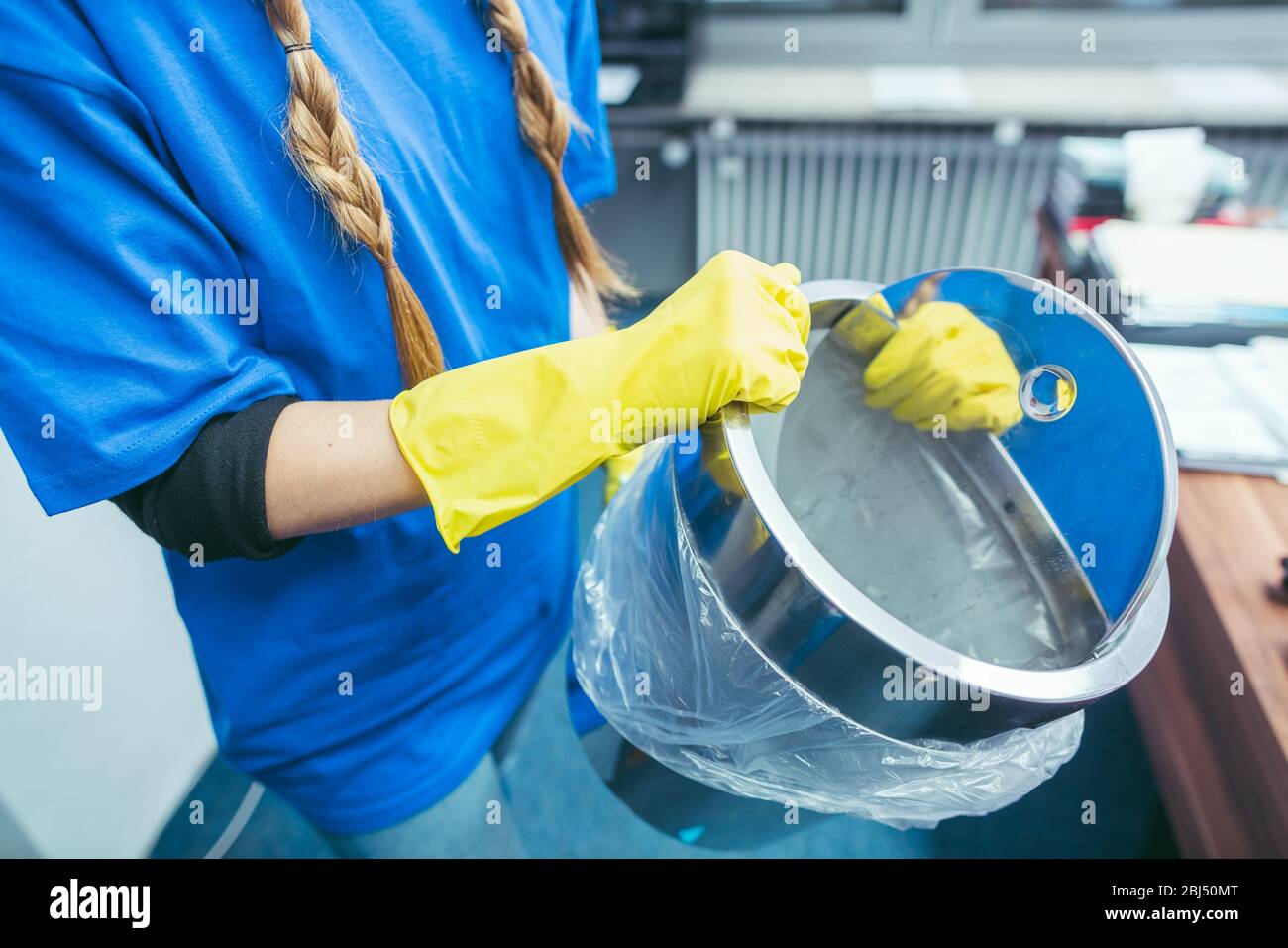 Commercial cleaning lady emptying rubbish bin Stock Photo - Alamy