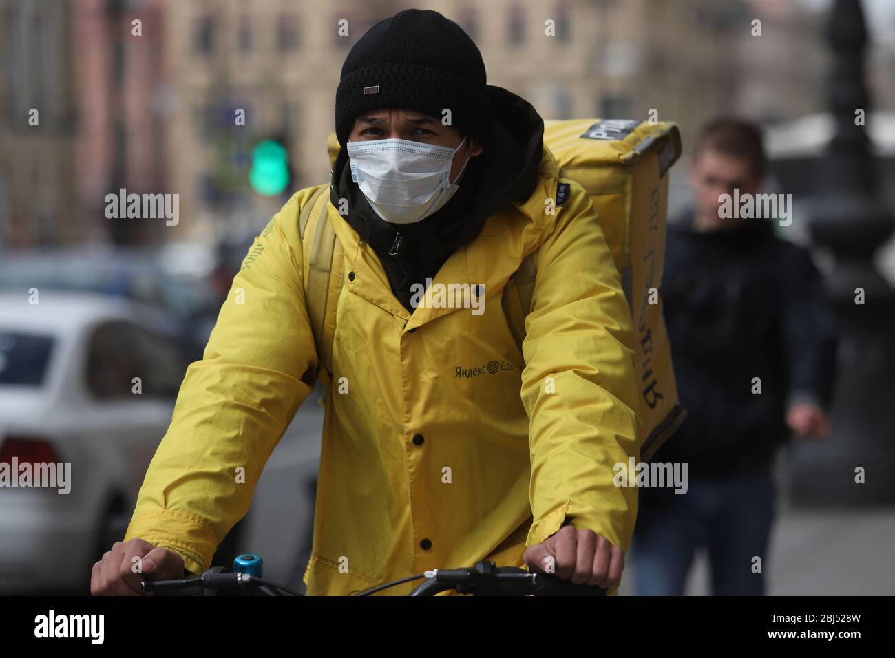 A courier of Yandex Eda company wearing a face mask as a precaution ...