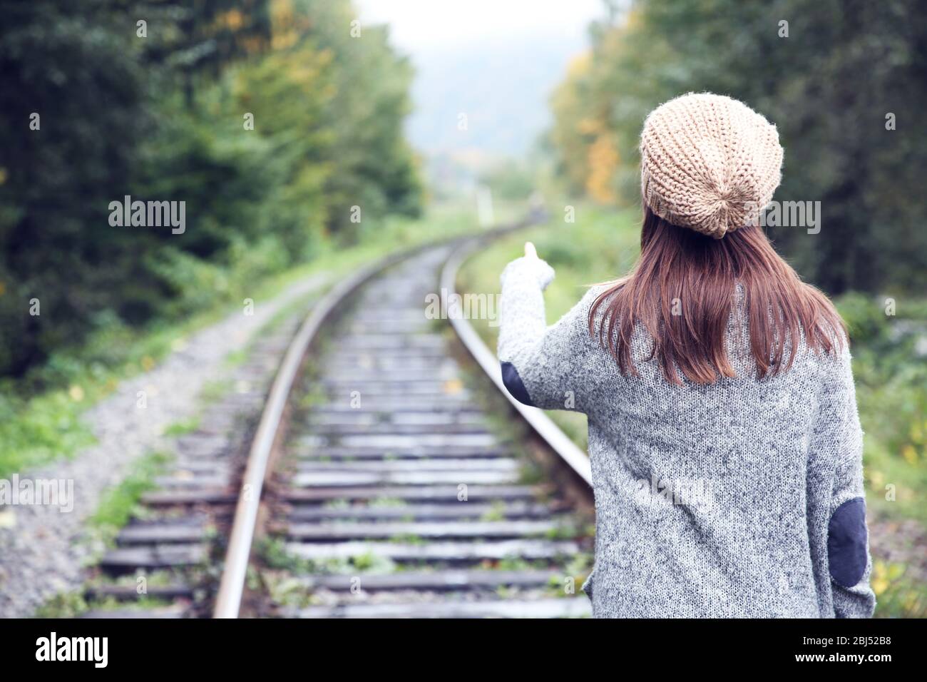 Young woman walking on rail of railway tracks Stock Photo - Alamy
