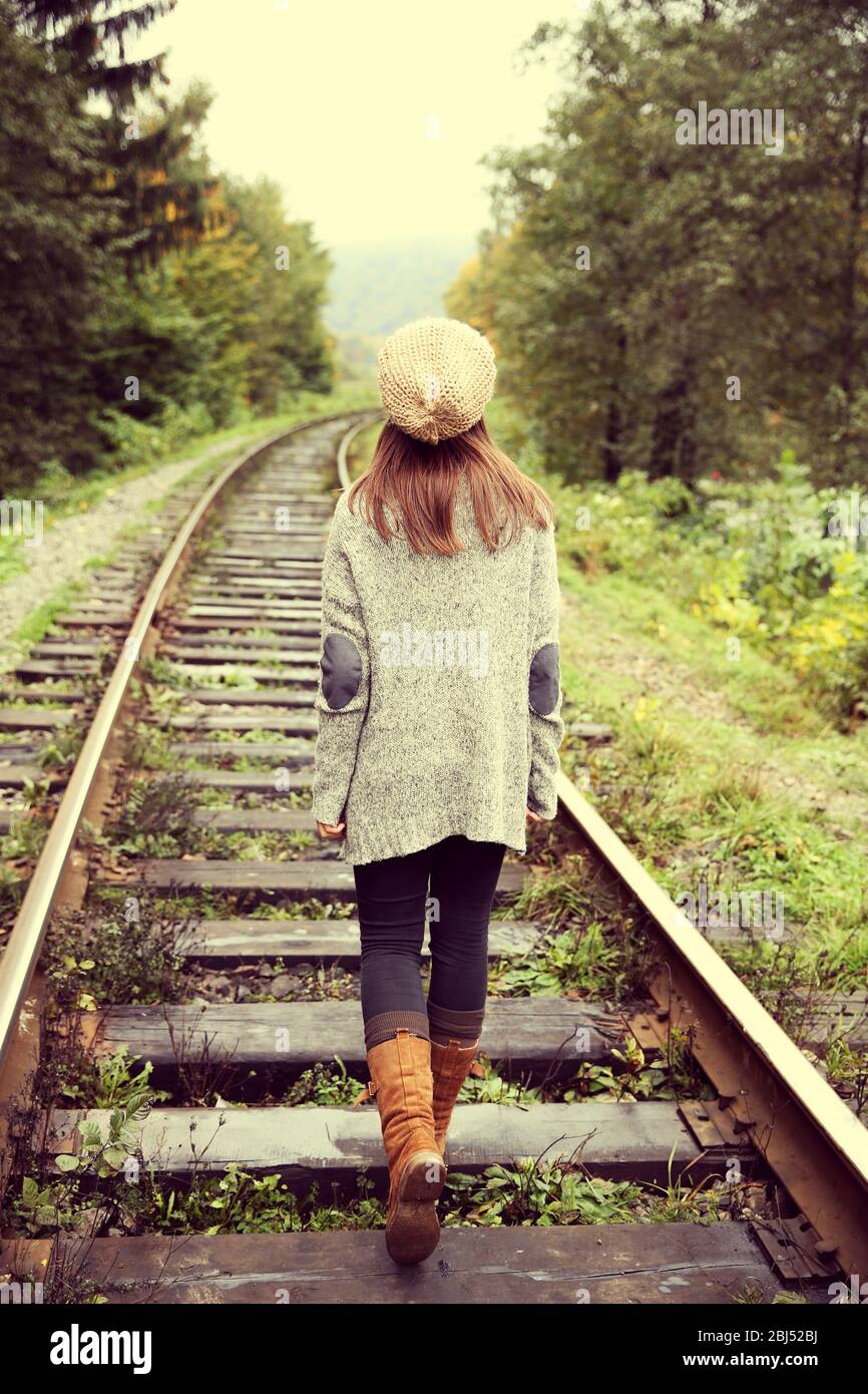 Young woman walking on rail of railway tracks Stock Photo - Alamy