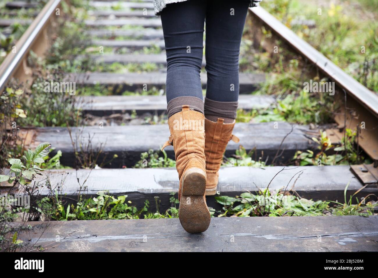Young woman walking on rail of railway tracks Stock Photo - Alamy