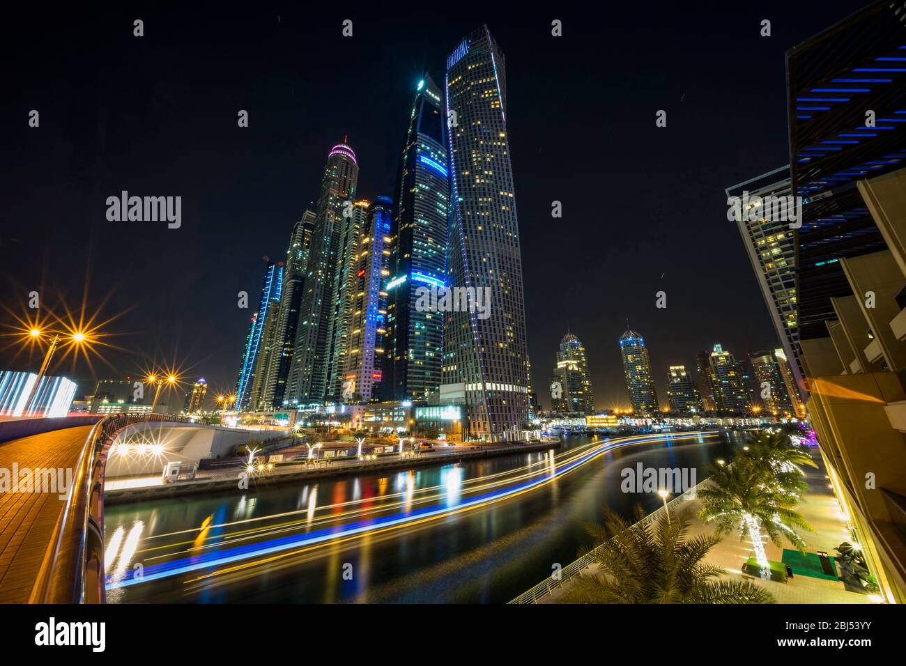 The colourful light trail from a passing Arabic dhow winds through the ...