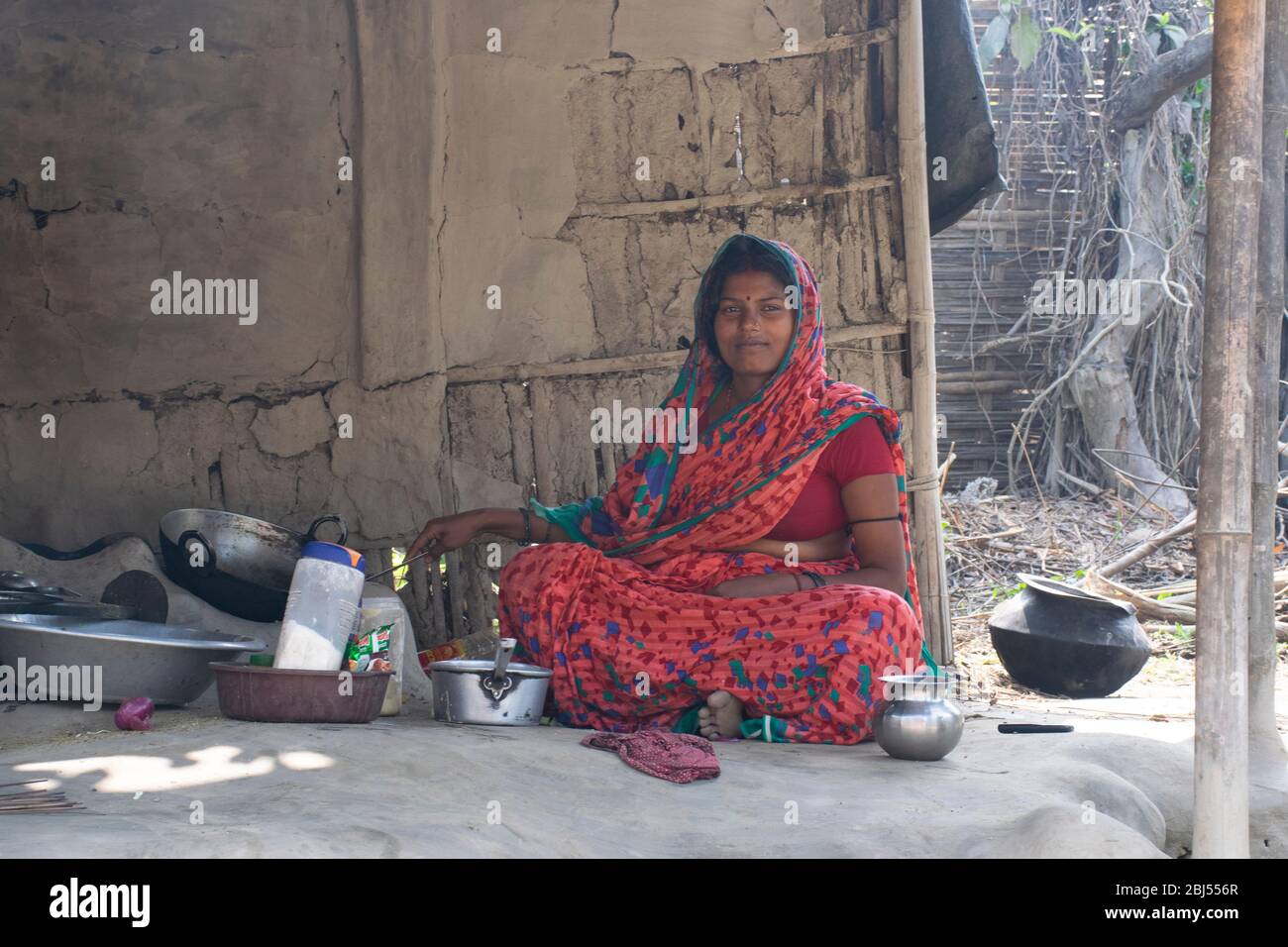 Rural Woman Cooking Food In The Kitchen Using Firewood Stove Stock