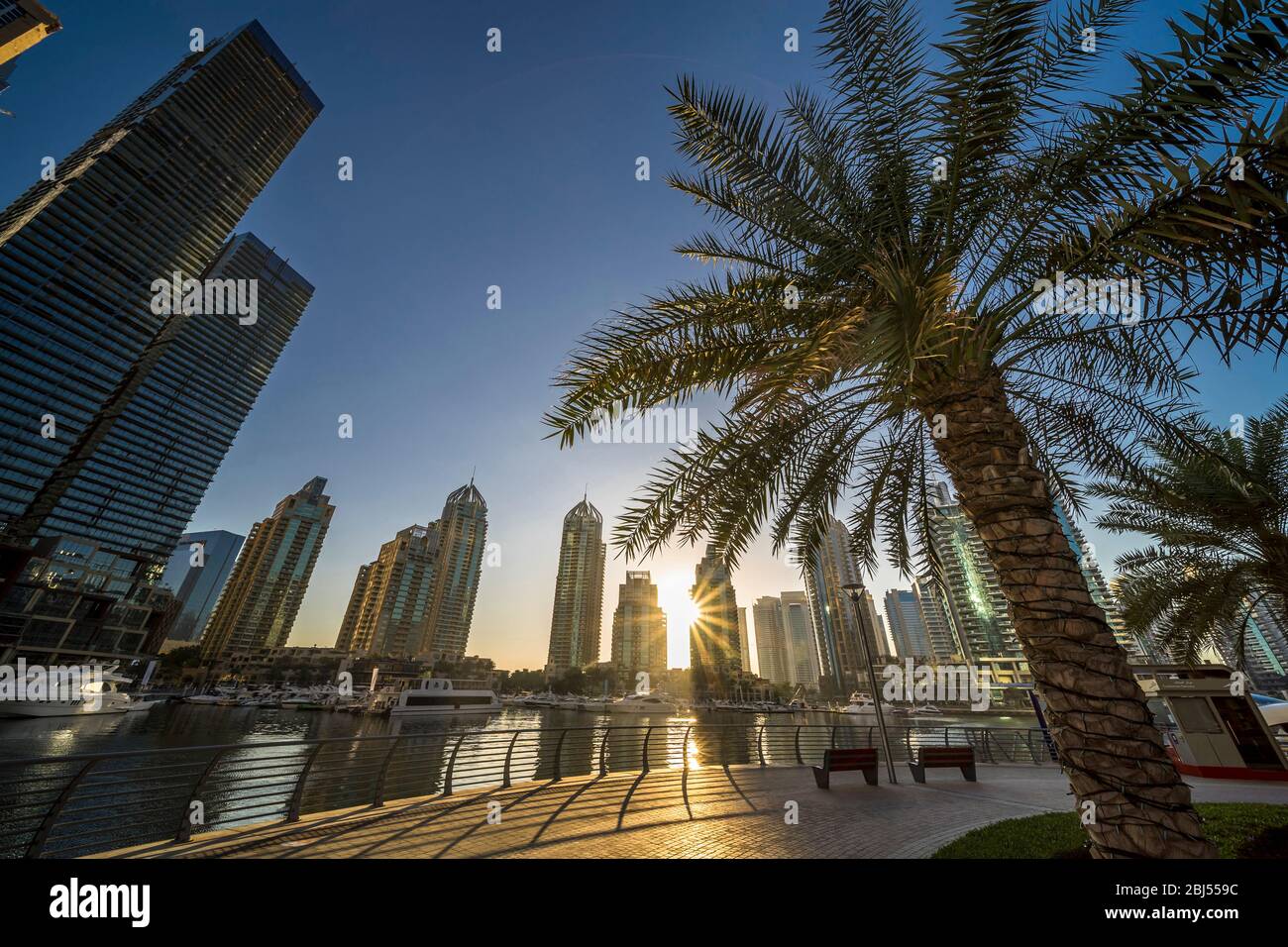 The sun breaks through skyscrapers and fills the Dubai Marina with ...