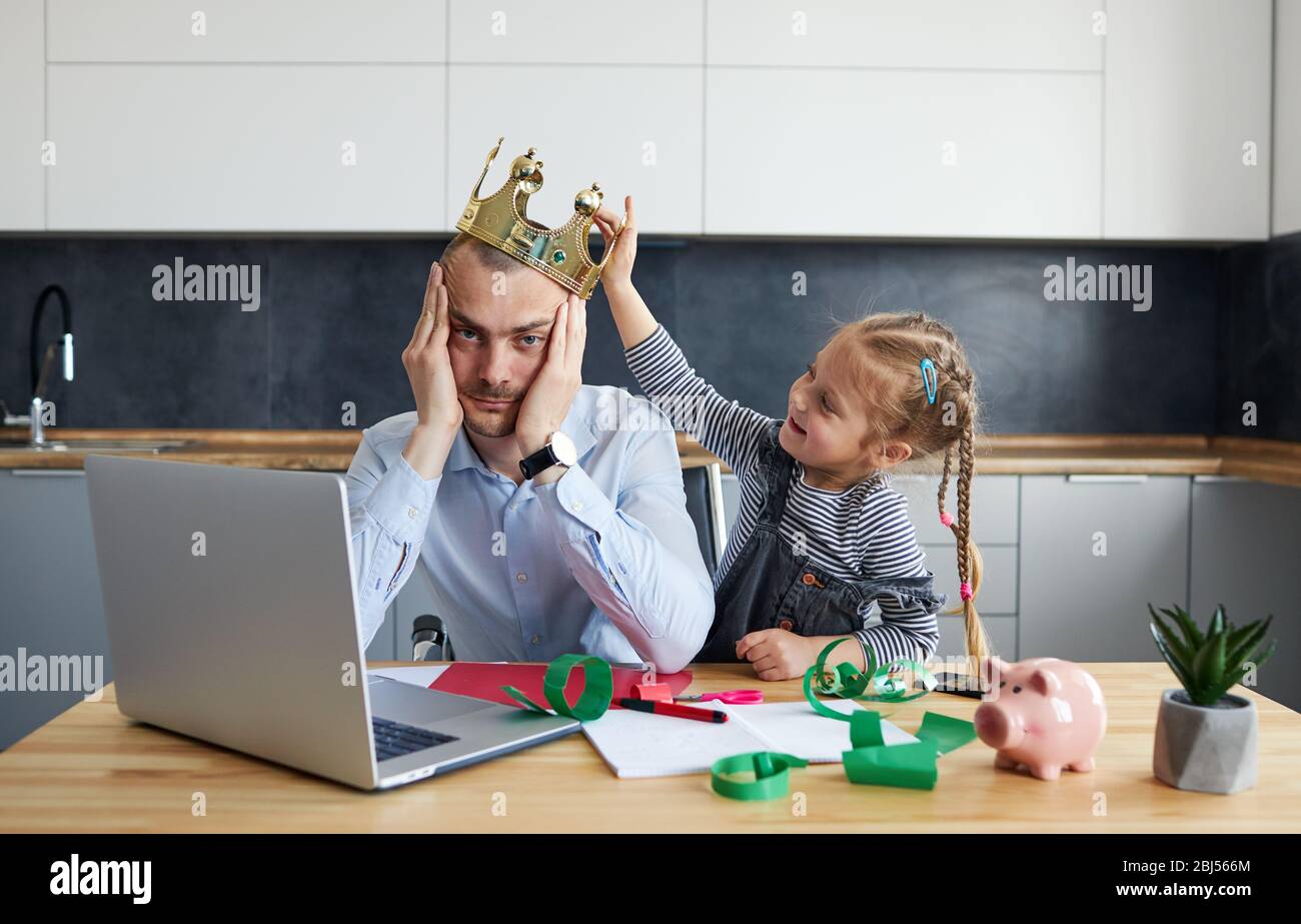 Tired Father Working from home on laptop during quarantine. Little ...