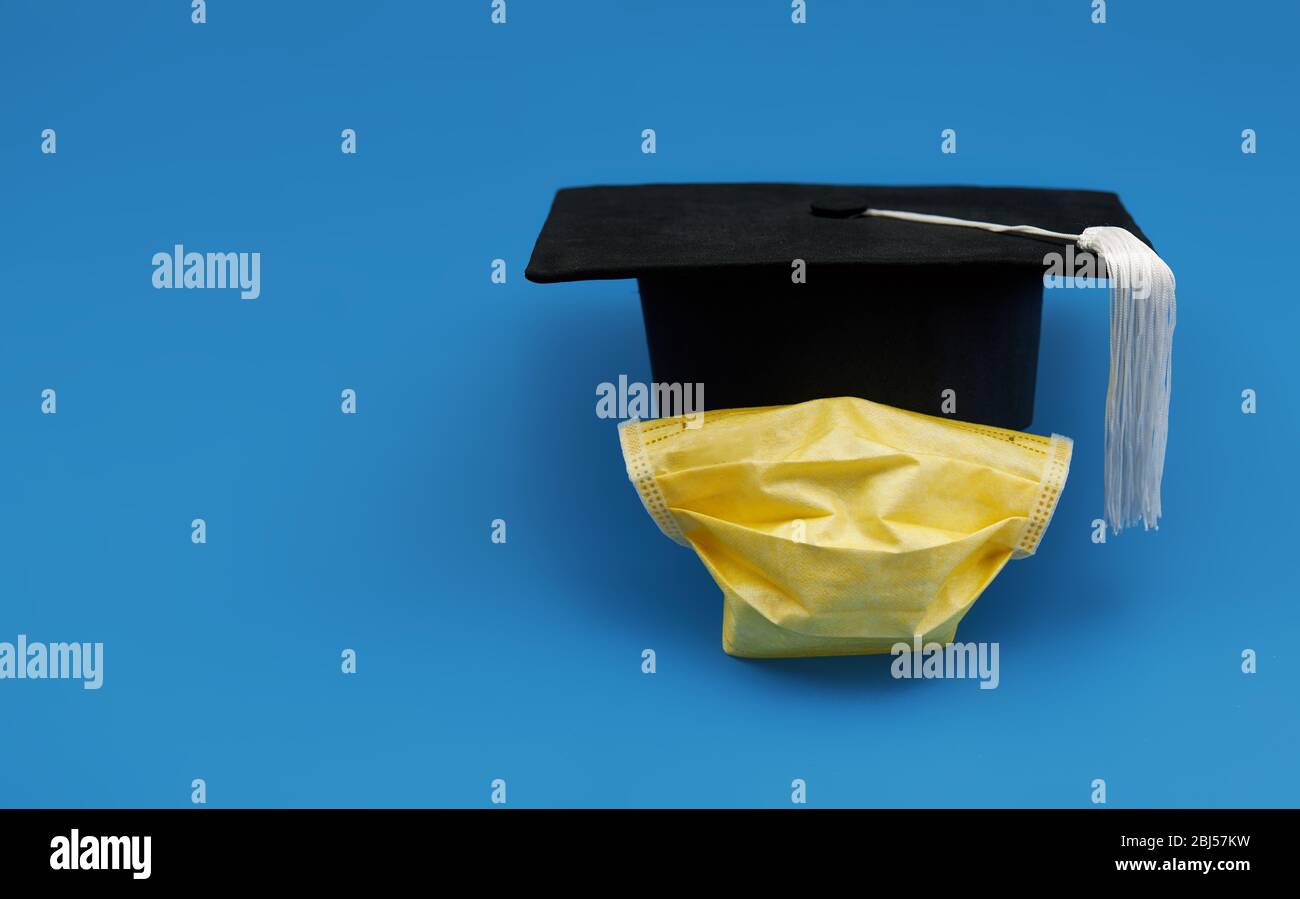 Graduation cap and face shield on blue isolated background Stock Photo ...
