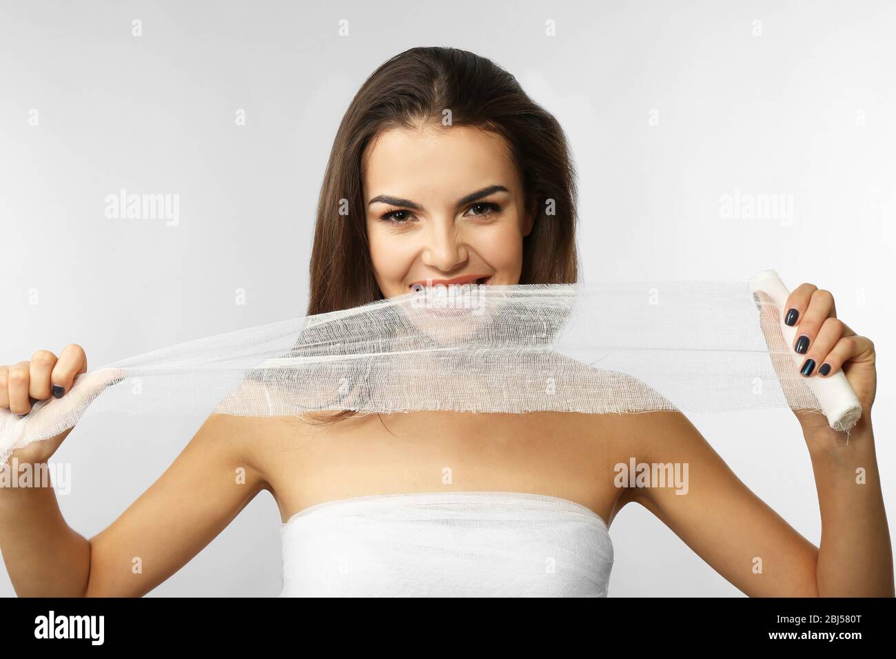 Young beautiful woman with a bandage on her chest, holding gauze ...