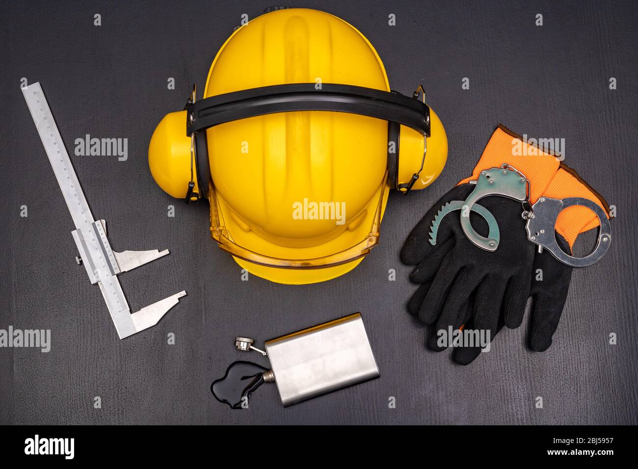Construction helmet, handcuffs and vodka in a bottle. Drunkenness at ...