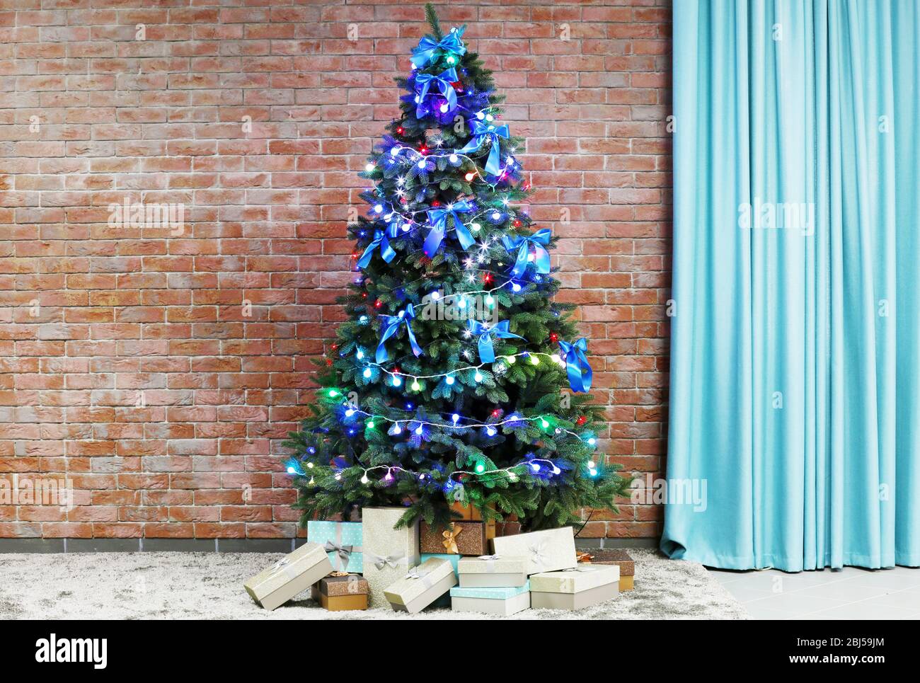 Christmas tree on brick wall background Stock Photo - Alamy