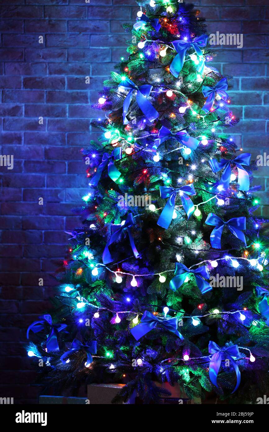 Christmas tree on brick wall background Stock Photo - Alamy
