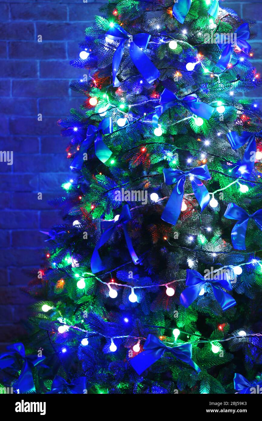 Christmas tree on brick wall background Stock Photo - Alamy