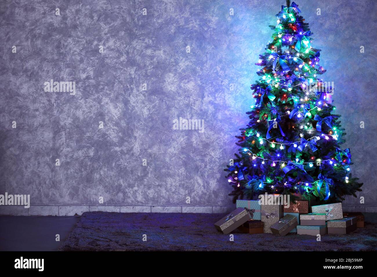 Christmas tree in a room on wall background Stock Photo - Alamy