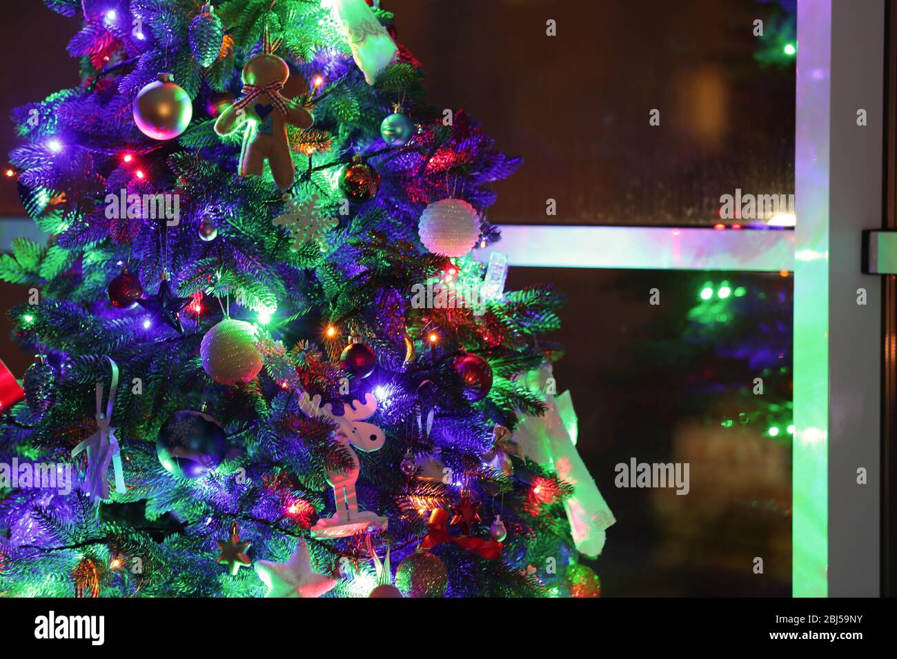Christmas tree on window background Stock Photo - Alamy