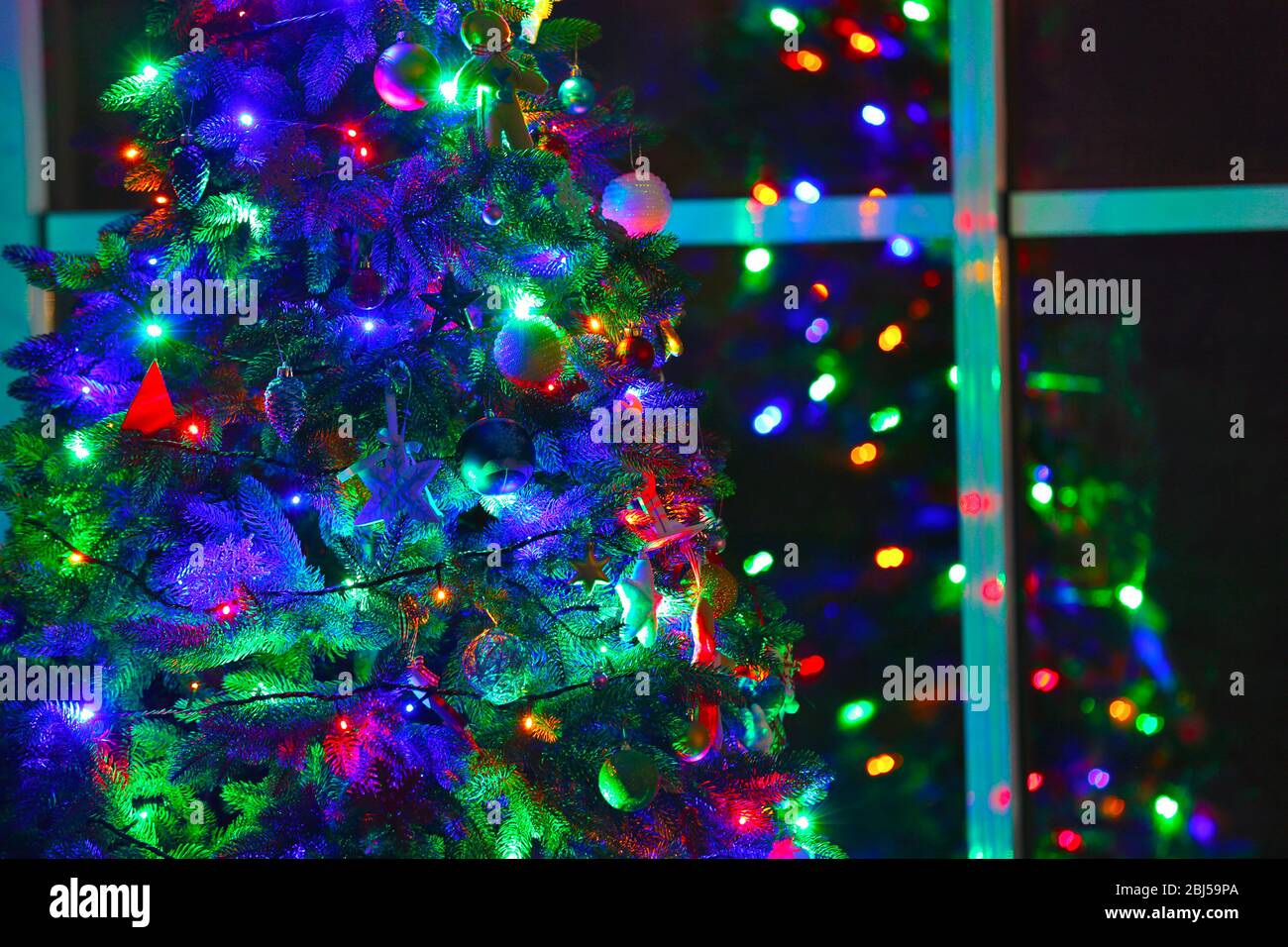 Christmas tree on window background Stock Photo - Alamy