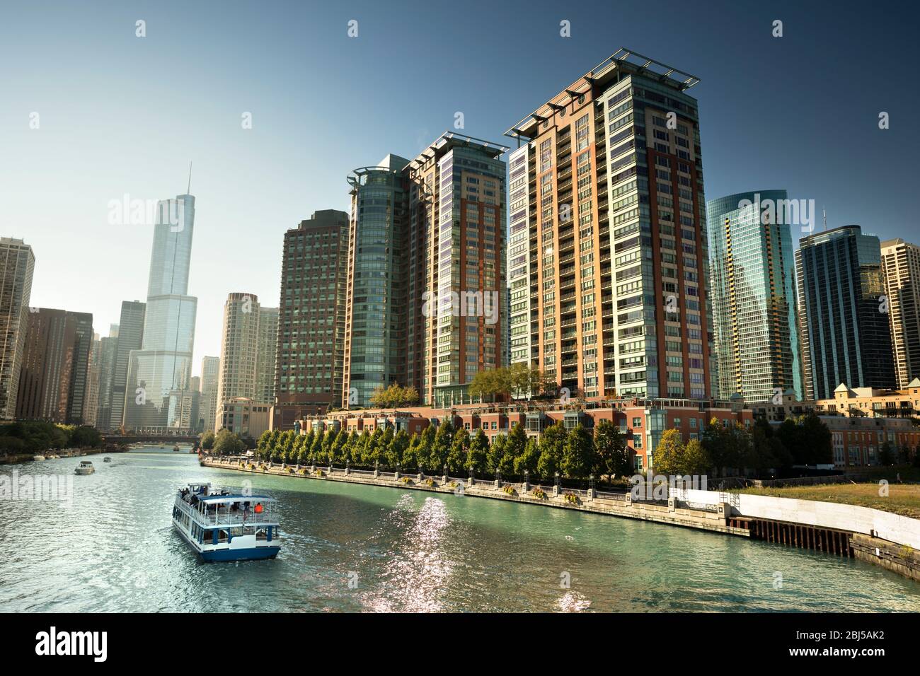 Boats float down the Chicago River skyline in downtown Chicago Illinois ...
