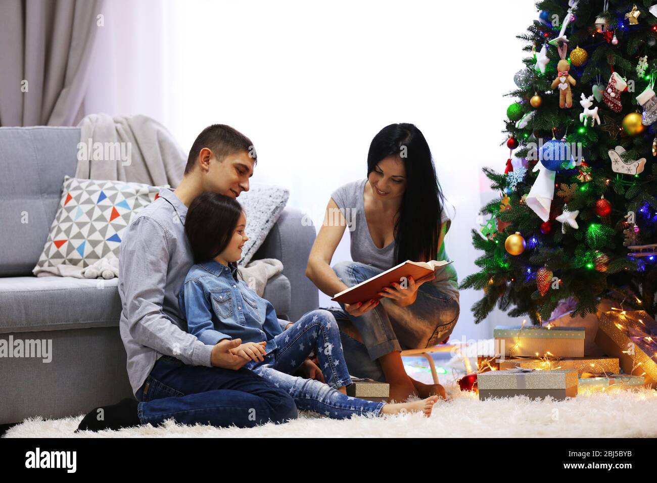 Happy family read book in the decorated Christmas room Stock Photo - Alamy