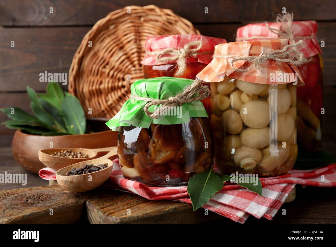 Jars with pickled vegetables and beans on wooden background Stock Photo ...