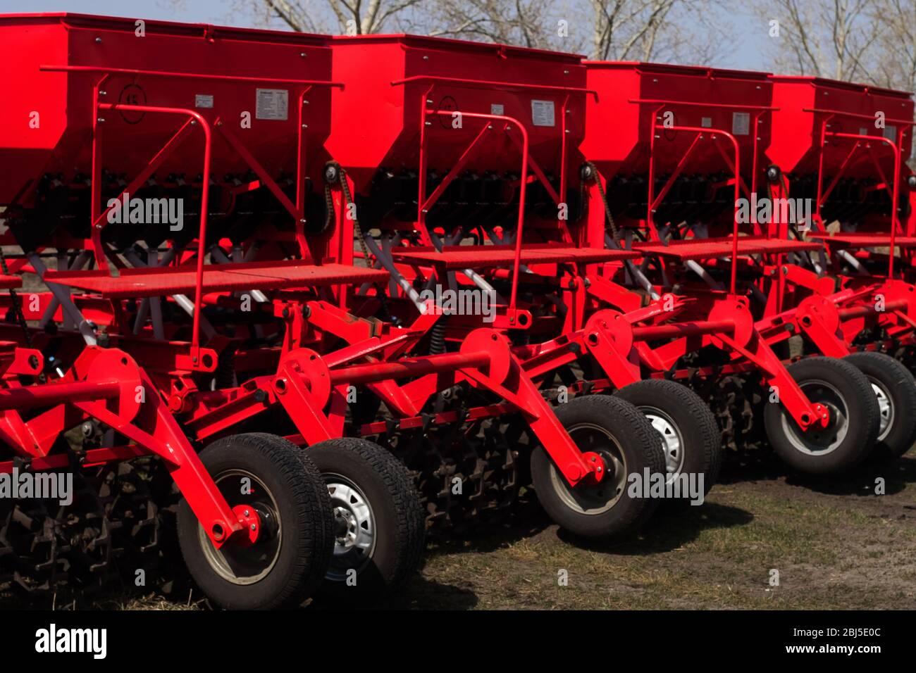 Red combine and plow, trailed sprayer with tank and liquid. Machinery ...