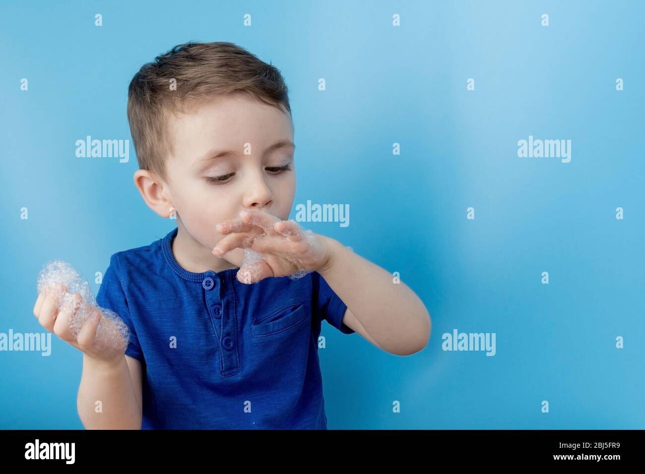 Child showing his hands with soap lather, cleaning and hygiene concept ...