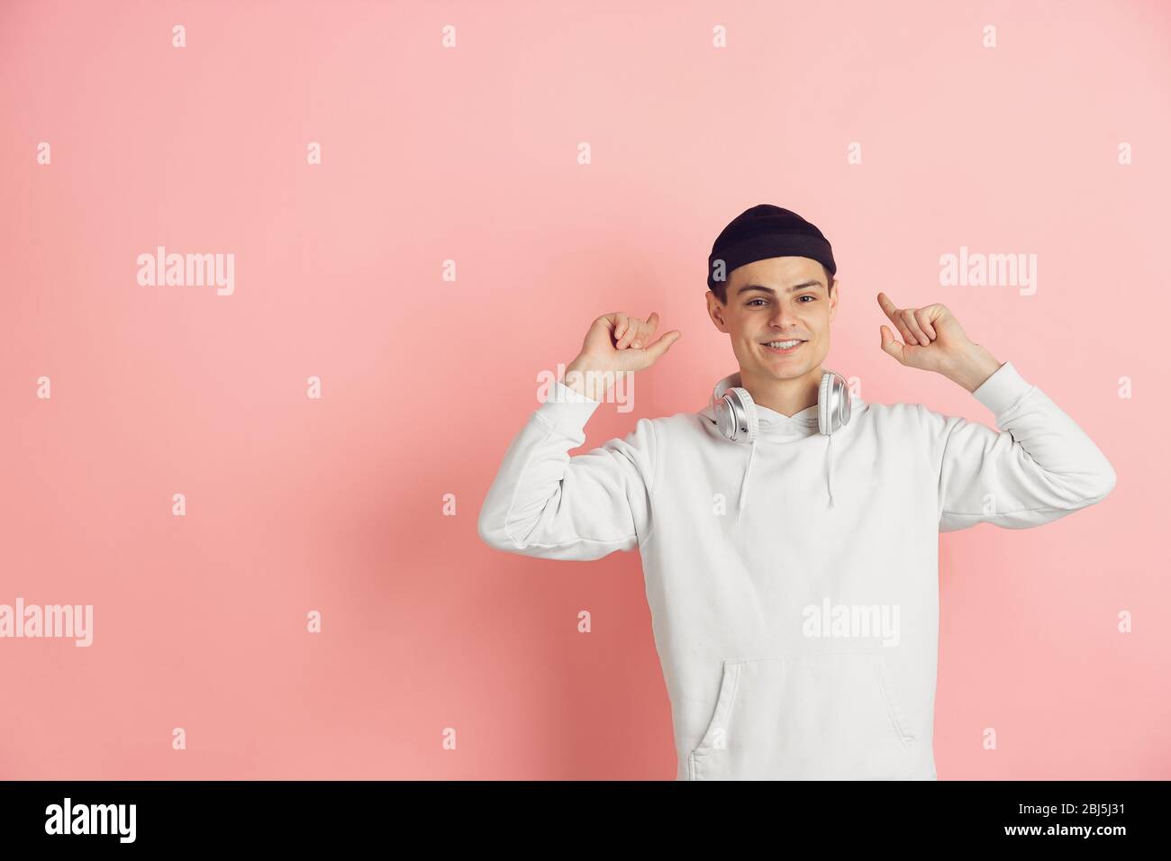 Pointing, choosing. Caucasian young man's modern portrait isolated on ...