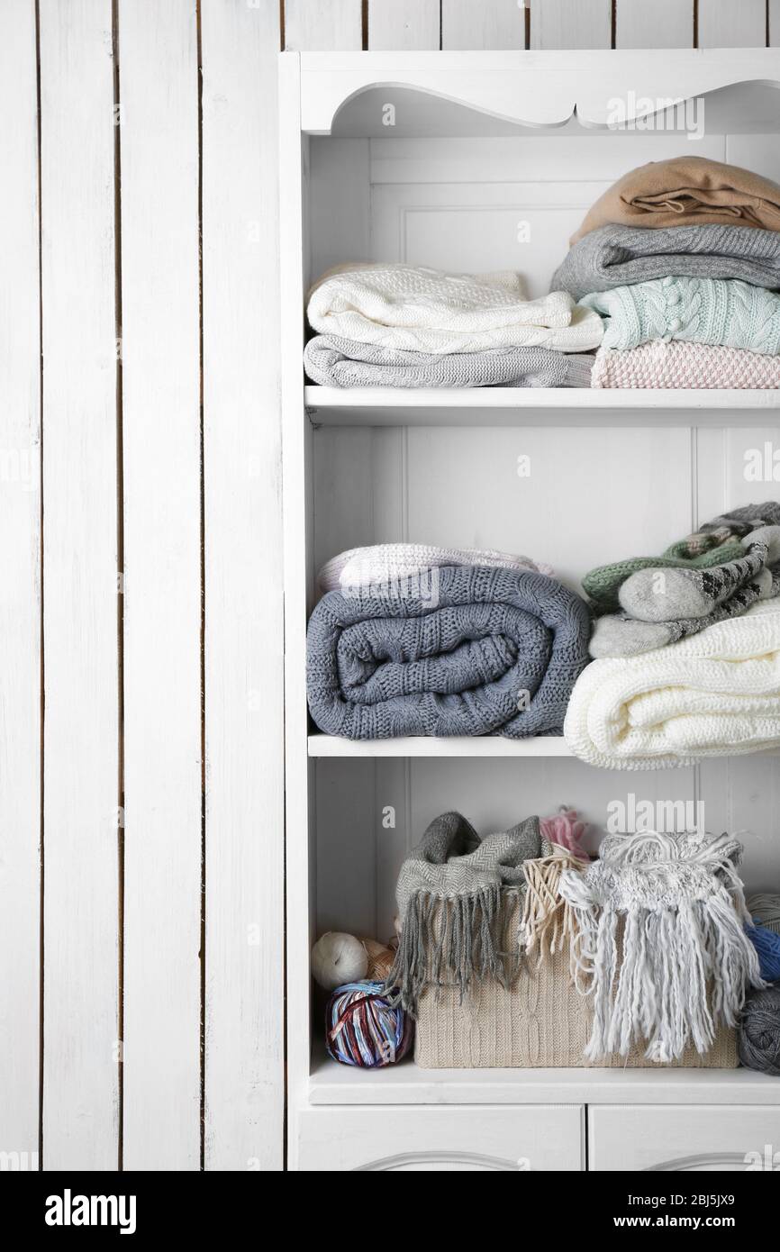 Knitting clothes on wooden shelf Stock Photo - Alamy