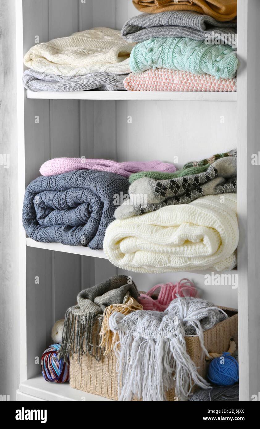 Knitting clothes on wooden shelf Stock Photo - Alamy