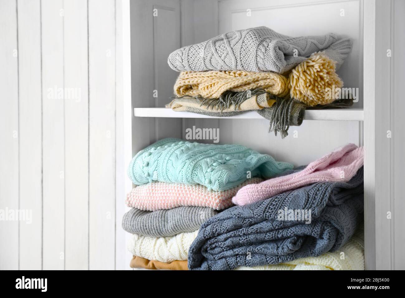 Knitting clothes on wooden shelf Stock Photo - Alamy