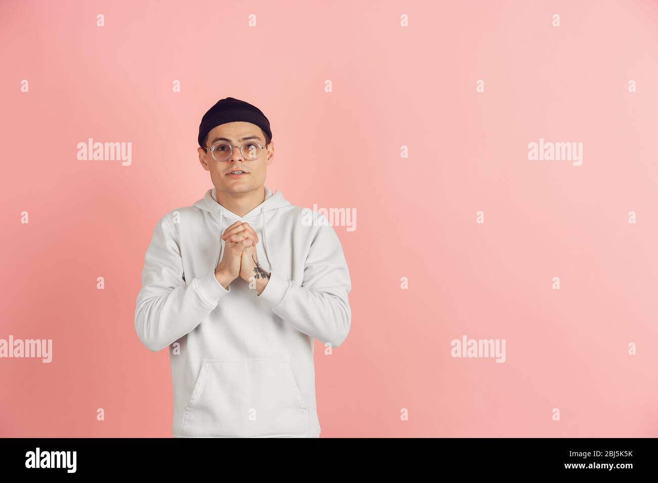 Praying, looks calm. Caucasian young man's modern portrait isolated on ...
