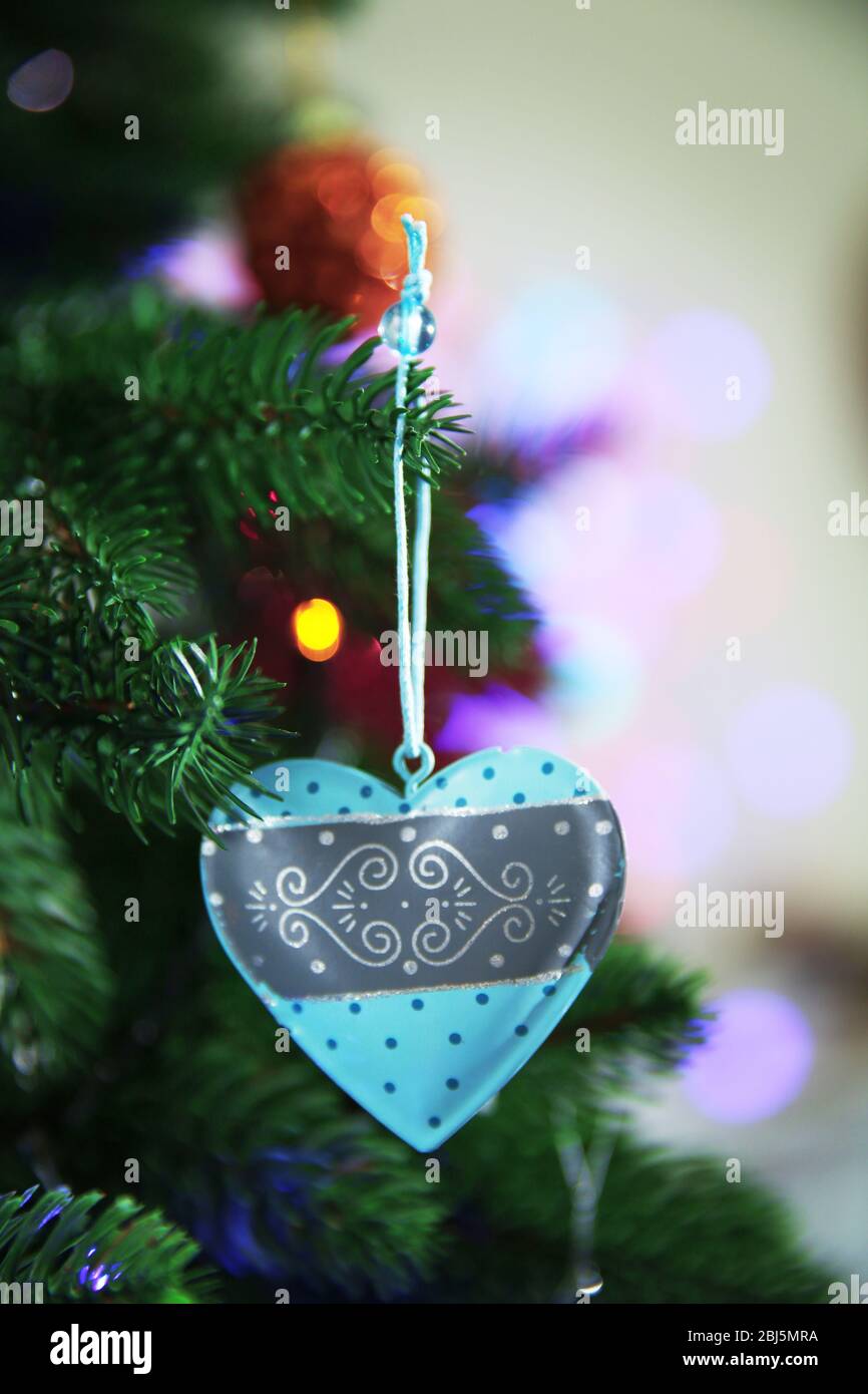 Christmas blue heart on a fir tree over blurred background, close-up ...