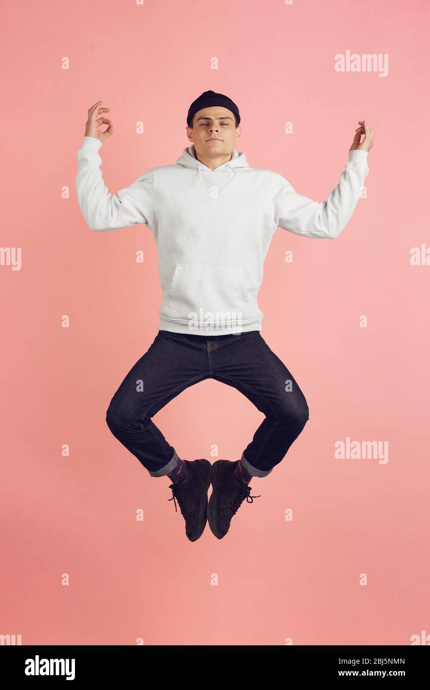 Calming yoga. Caucasian young man's modern portrait isolated on pink ...