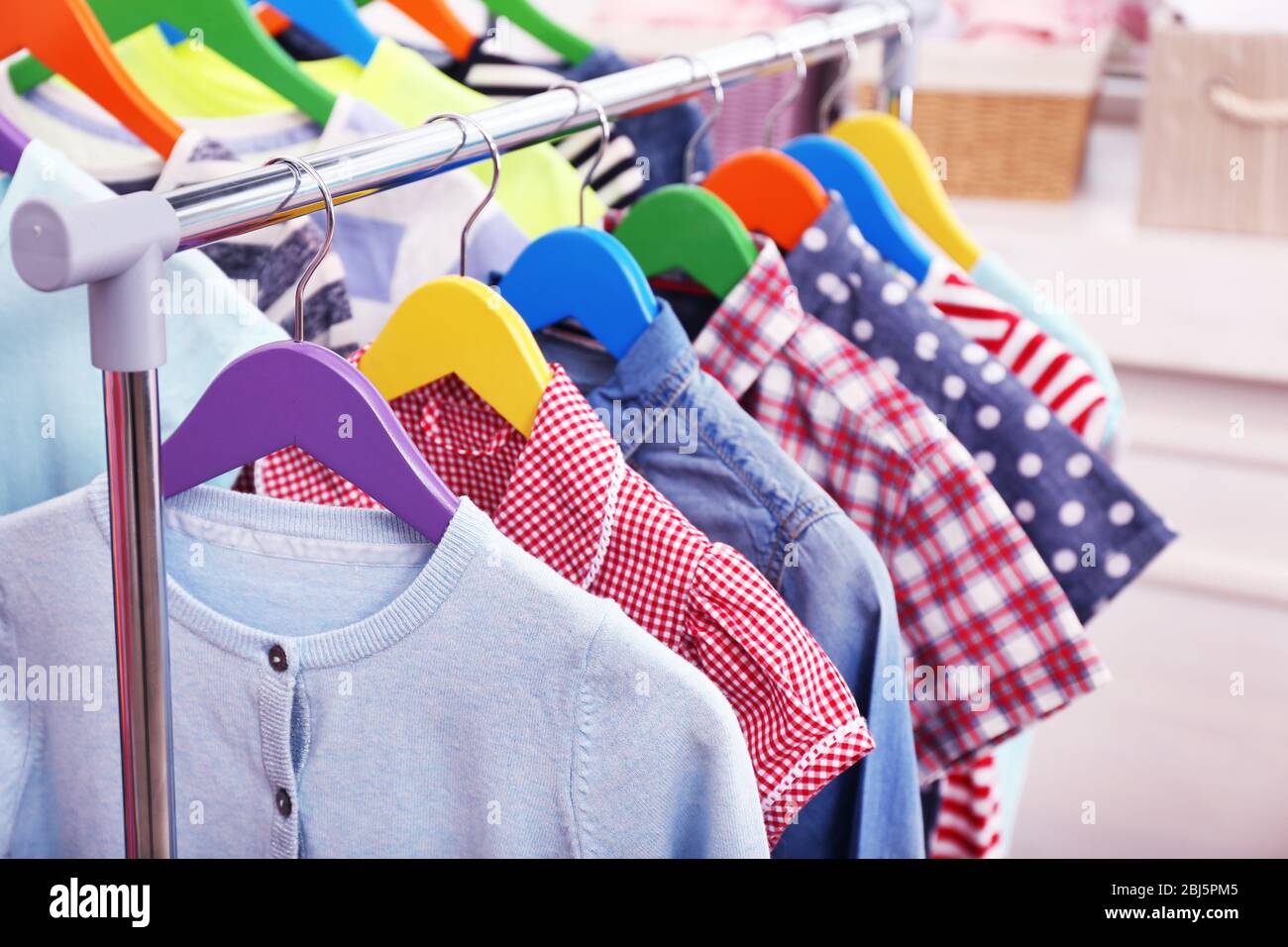 Clothes for children on hangers in a room Stock Photo - Alamy