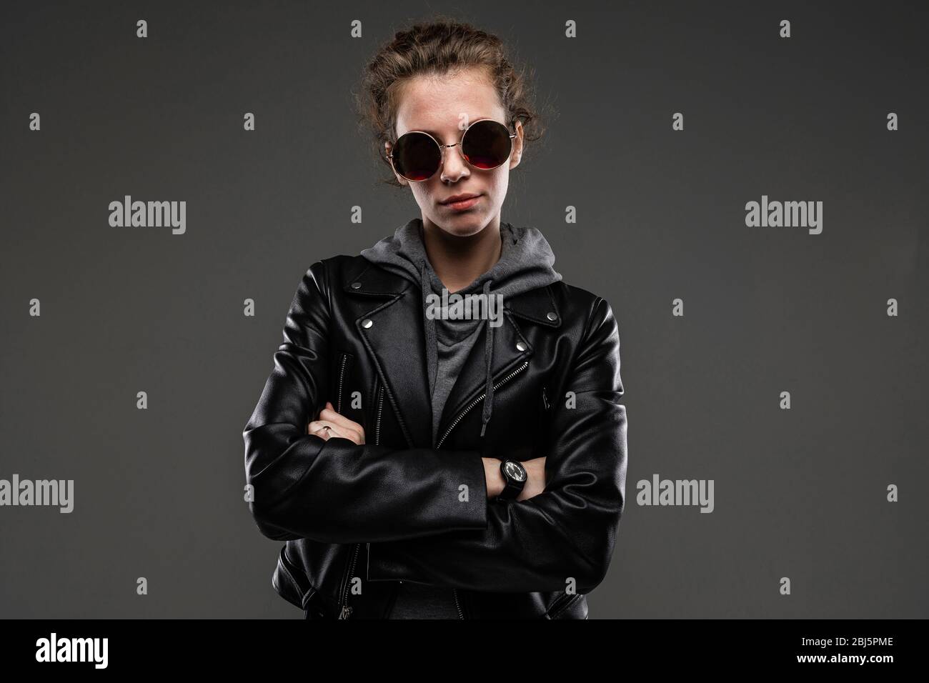Self-confident girl with rough facial features in a black jacket ...