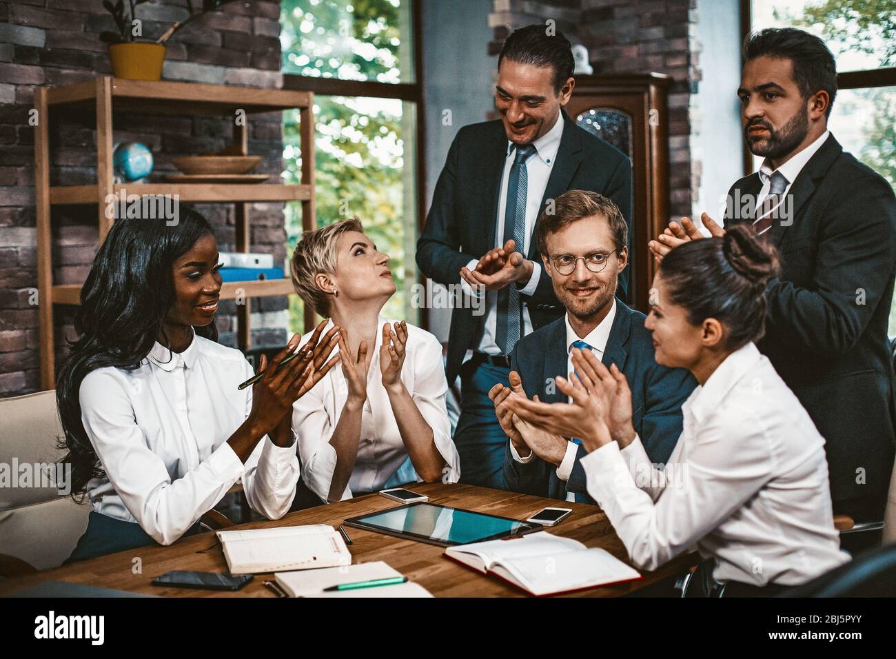 Happy Colleagues Claping Their Hands Together Stock Photo - Alamy