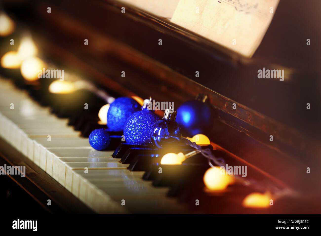 Piano keys decorated with decorative lights and balls, close up Stock ...