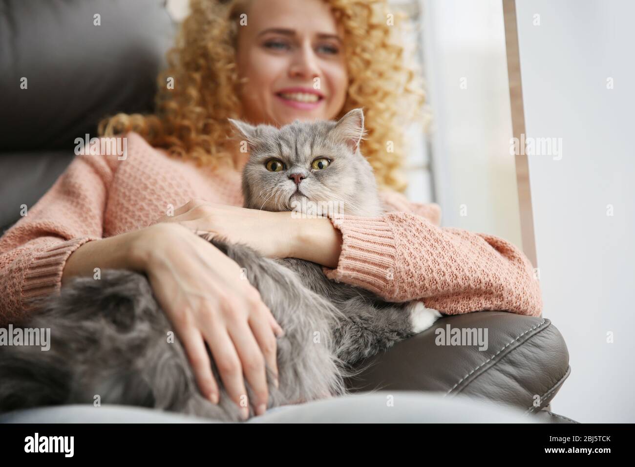 Young woman and cat beside window in the room Stock Photo - Alamy