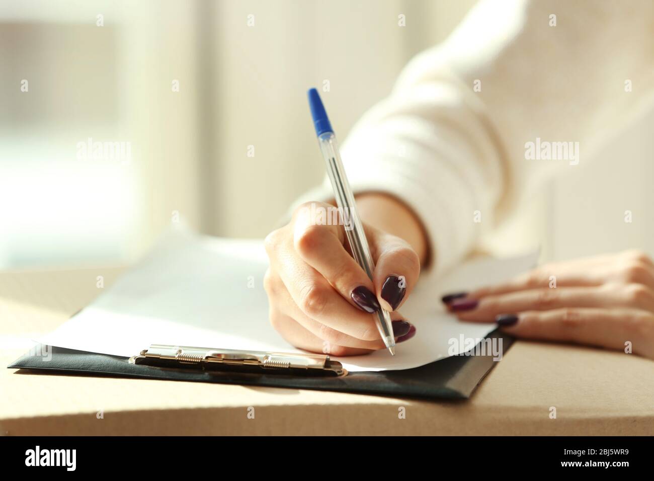Woman signing receipt of delivery package, close up Stock Photo - Alamy