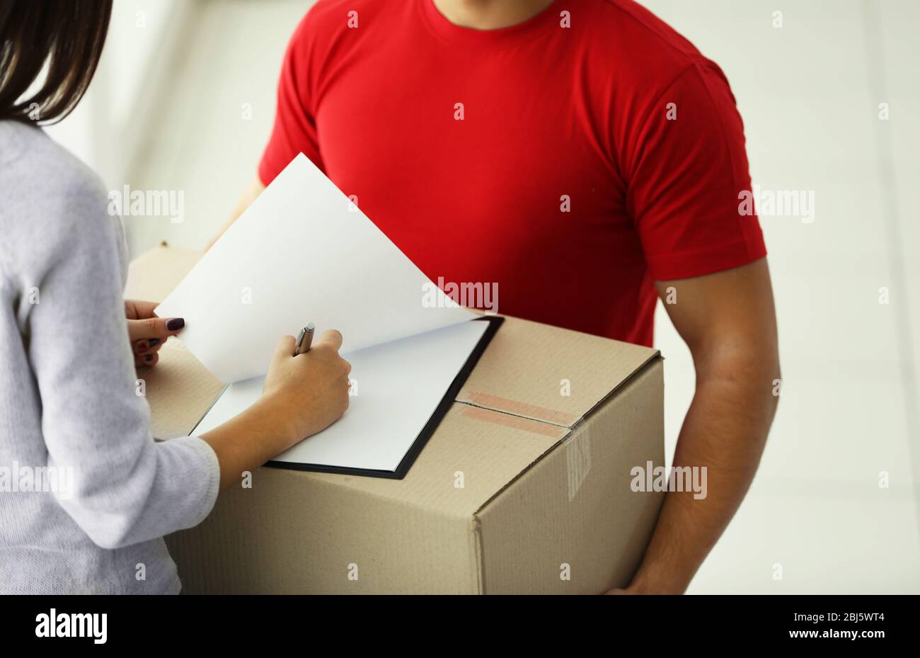 Woman signing receipt of delivery package, close up Stock Photo - Alamy