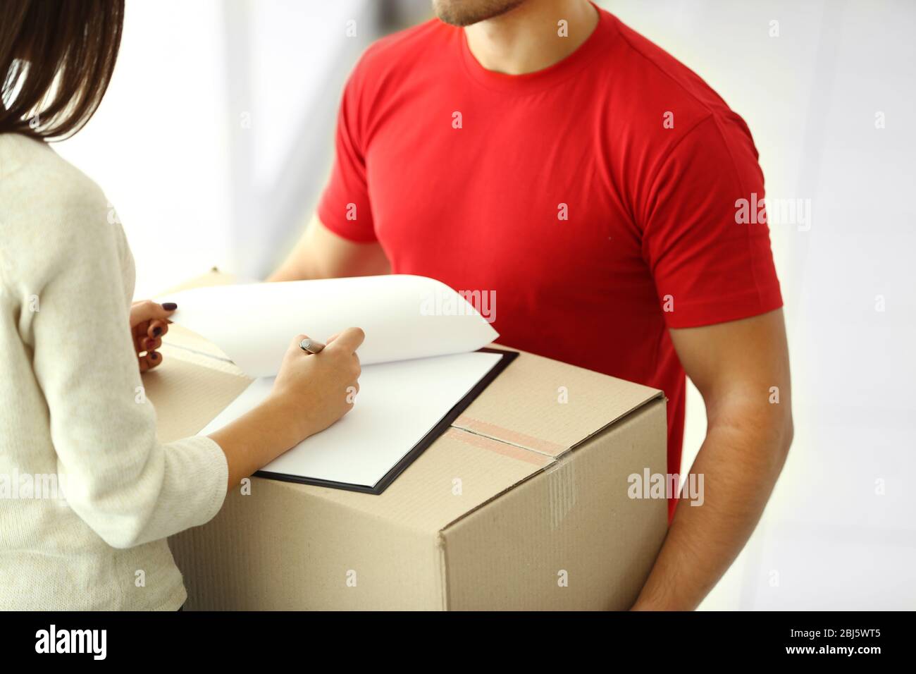 Woman signing receipt of delivery package, close up Stock Photo - Alamy