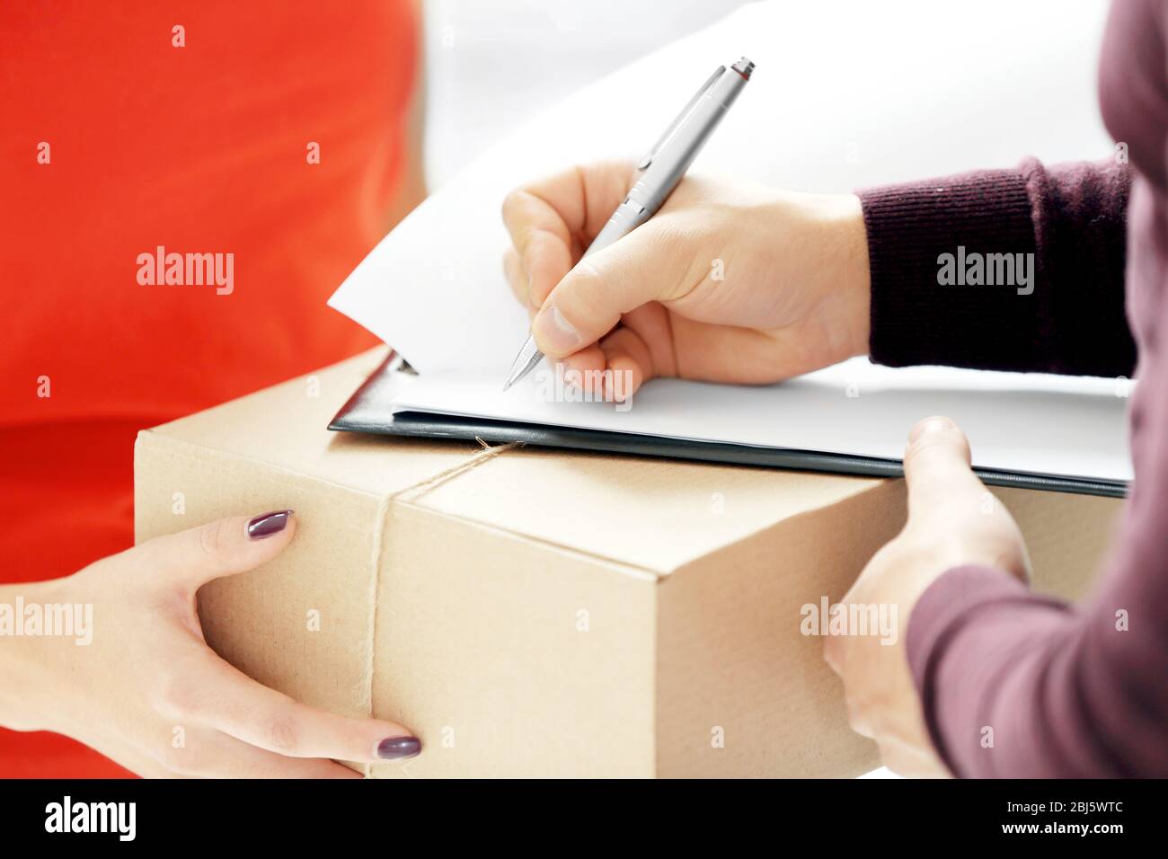 Man signing receipt of delivery package, close up Stock Photo - Alamy
