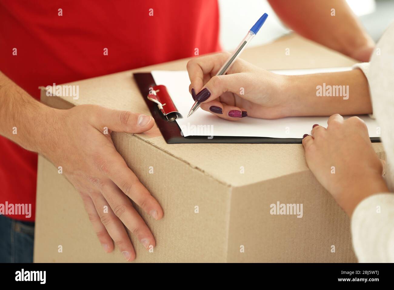 Woman signing receipt of delivery package, close up Stock Photo - Alamy