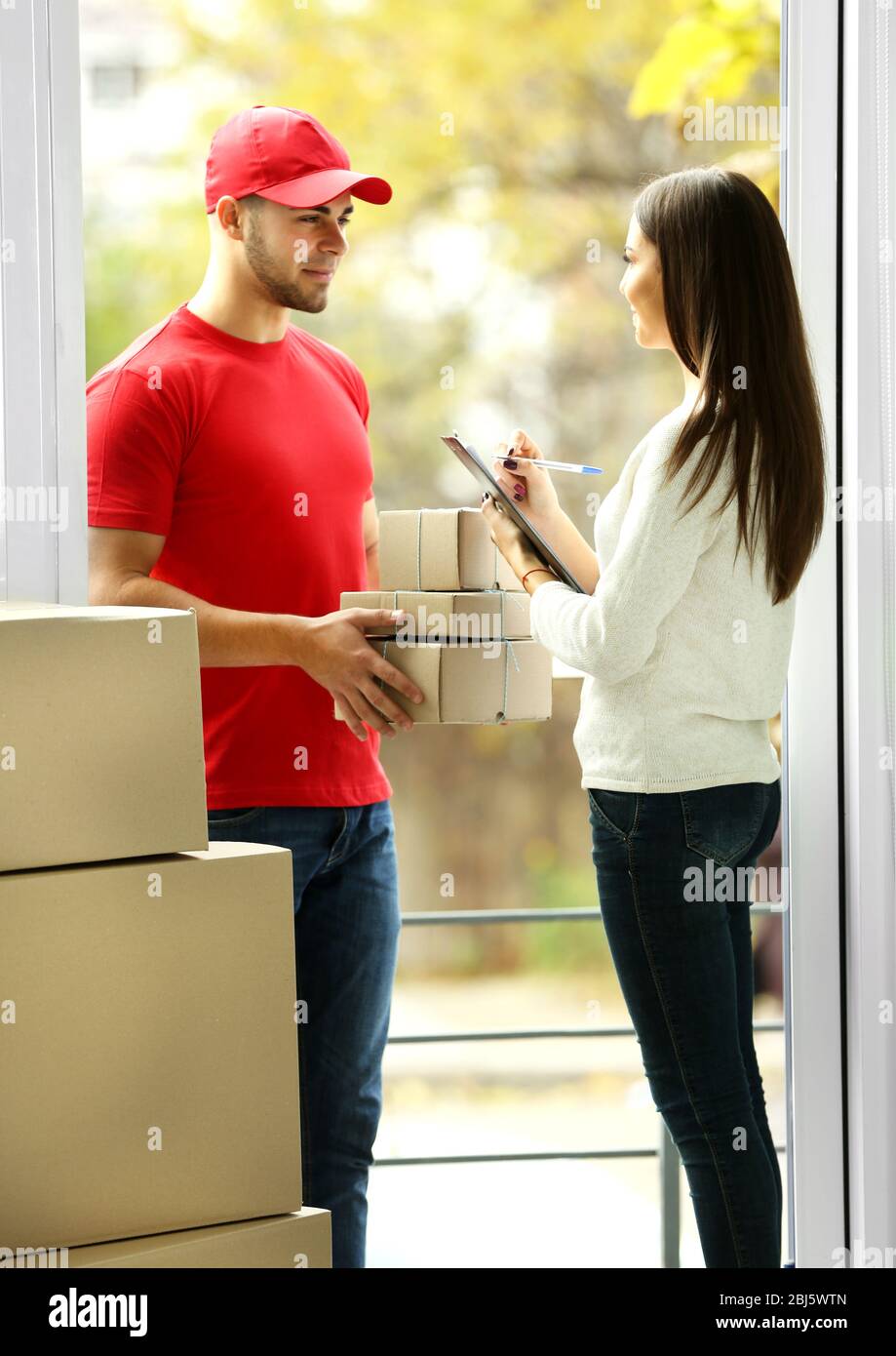Young woman and delivery man Stock Photo - Alamy