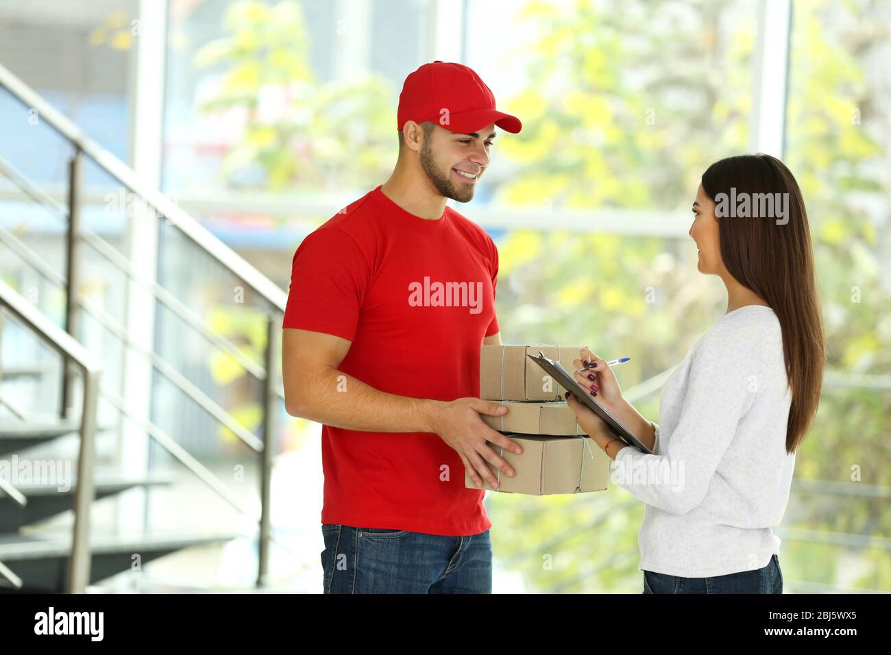 Young woman and courier - delivery concept Stock Photo - Alamy