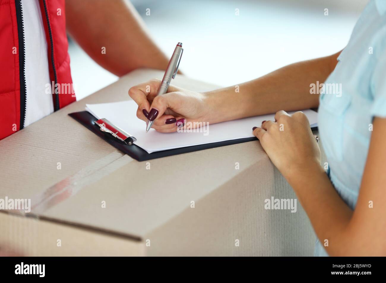 Woman signing receipt of delivery package, close up Stock Photo - Alamy