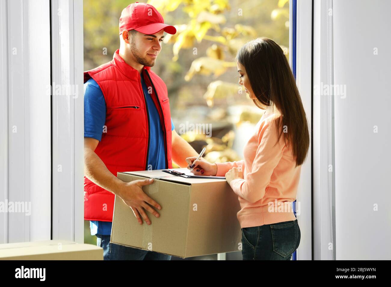 Young woman receiving parcel hi-res stock photography and images - Alamy