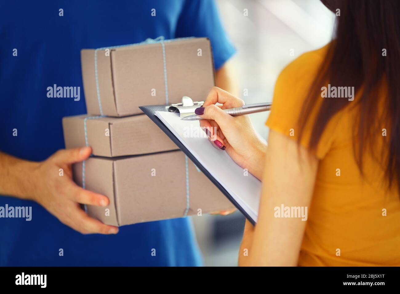 Woman signing receipt of delivery package, close up Stock Photo - Alamy