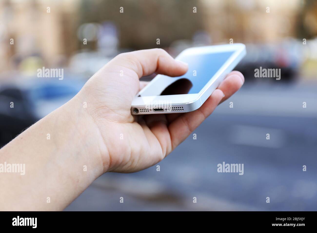 Woman holding smartphone outside Stock Photo - Alamy