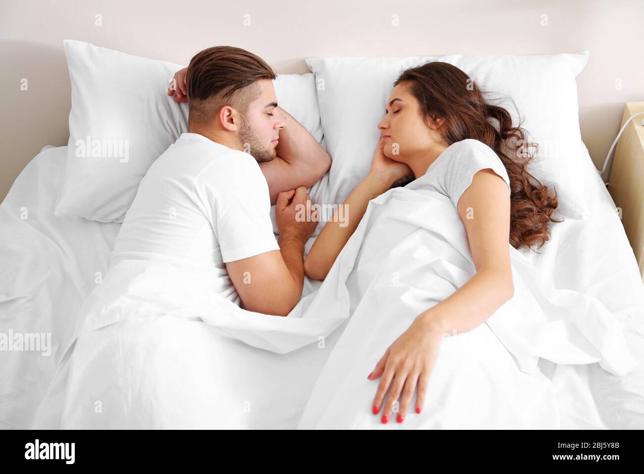 Happy couple snoozing on bed Stock Photo - Alamy